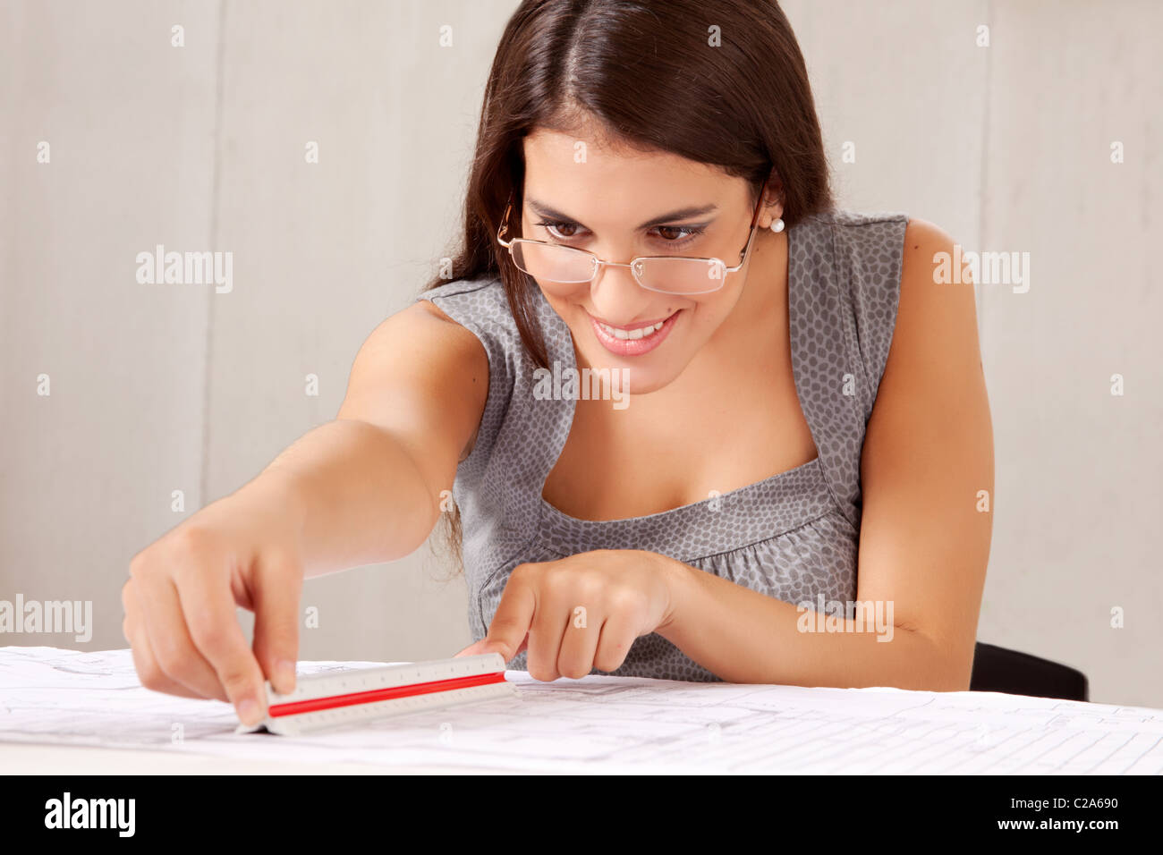 A female architect with a scale ruler measuring blueprints Stock Photo ...