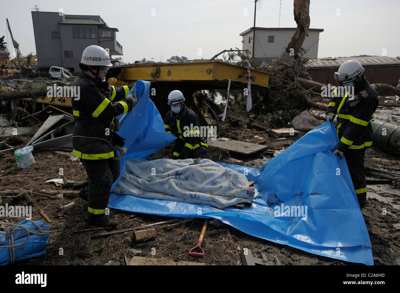 Fire fighters look for victims after the great earthquake and tsunami ...