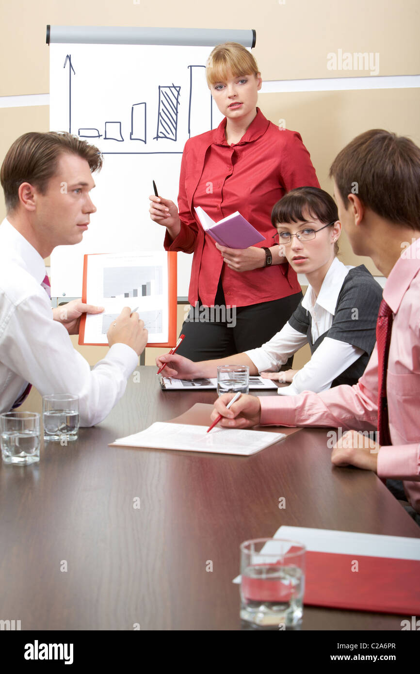 Vertical image of business team talking during meeting while confident ...