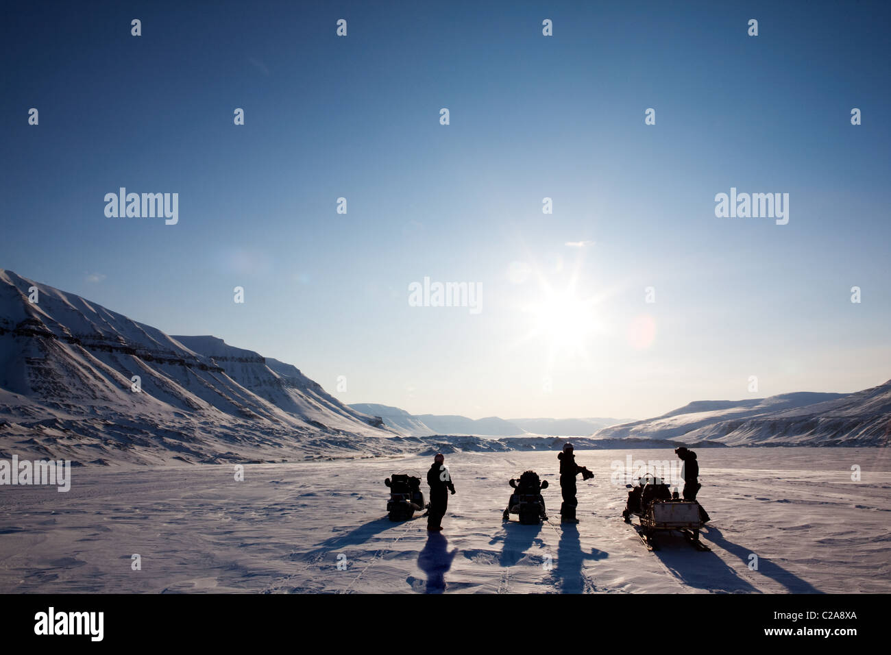 Three people on a winter snowmobile adventure in Svalbard, Norway Stock ...