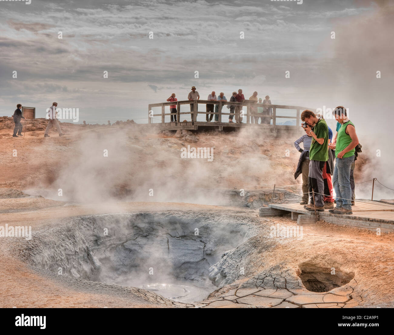 Tourist photographing boiling mud pot in the geothermal field ...