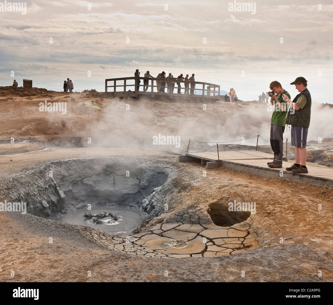 Tourist photographing boiling mud pot in the geothermal field ...
