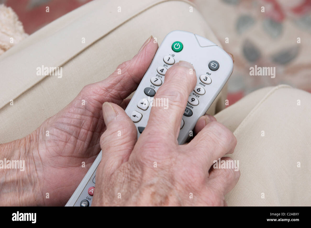 elderly woman using a remote control Stock Photo - Alamy