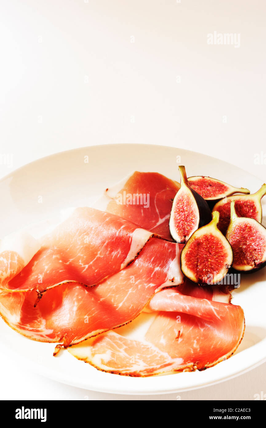 Parma ham and tiny bite-sized figs on a white plate Stock Photo - Alamy