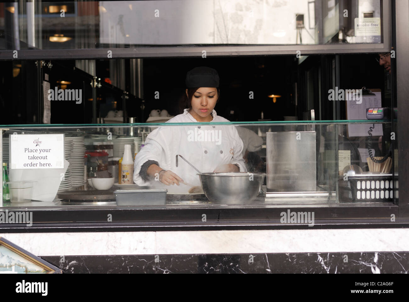 Beautiful young woman making crepes at a take out window located on ...
