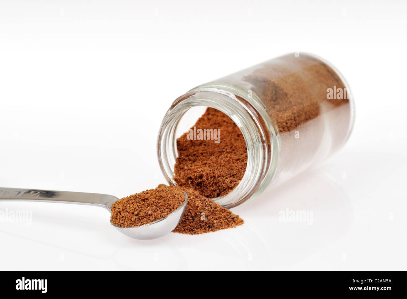 Bottle of the nutmeg spice open and on it side with nutmeg spilling out ...