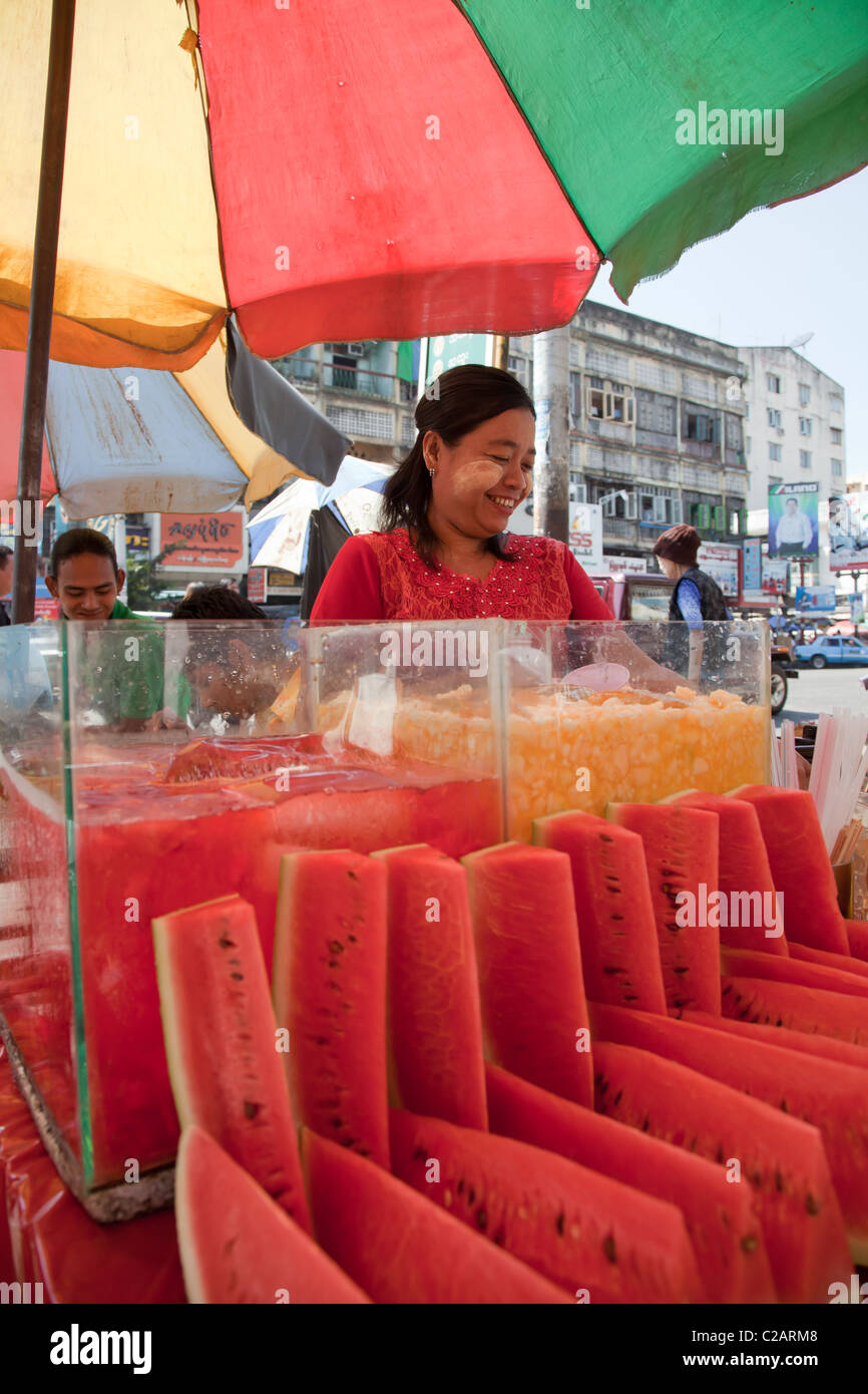 Woman with typical painted faces is selling watermelon on the street ...