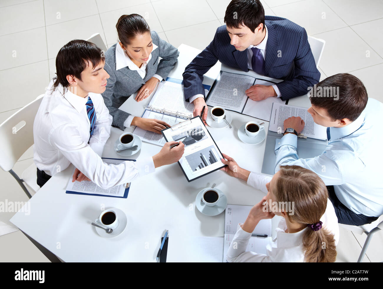 Above view of business team sitting around table and working with ...