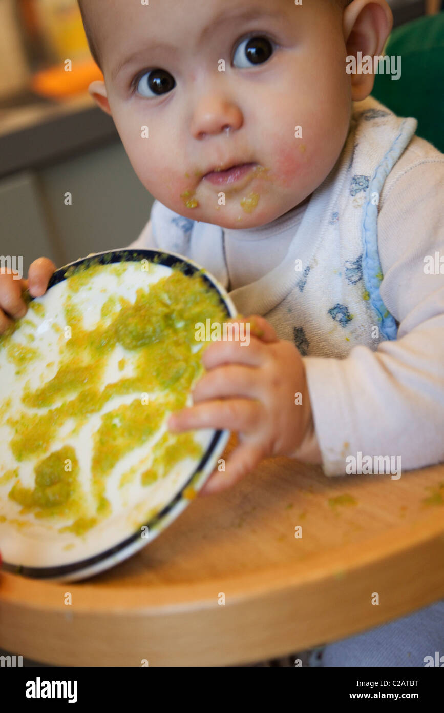 Baby girl making a mess with her food Stock Photo - Alamy