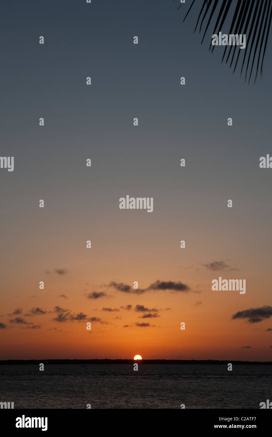 Sun setting over horizon Stock Photo - Alamy