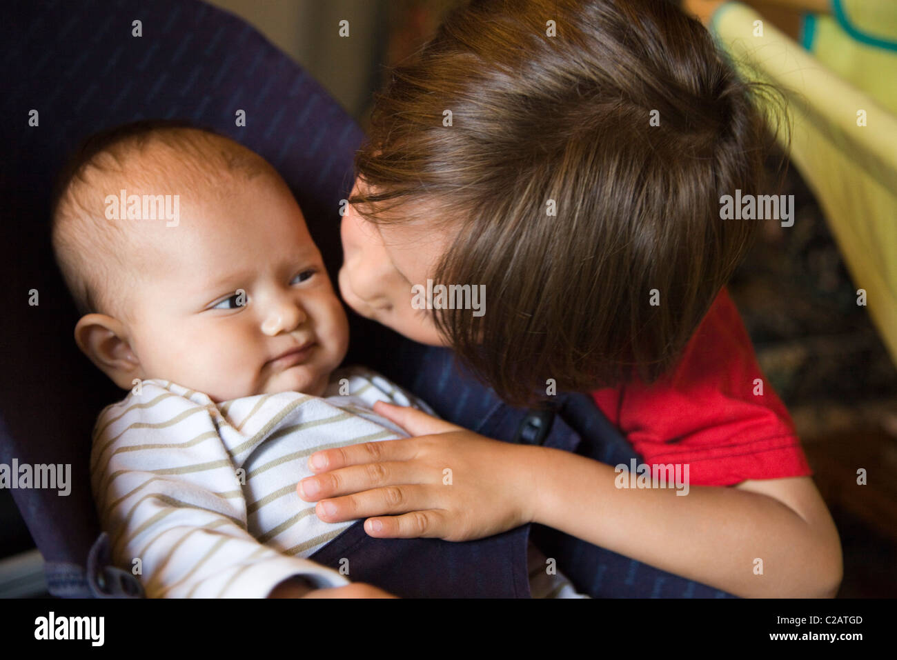 Young boy caring for baby sibling Stock Photo - Alamy