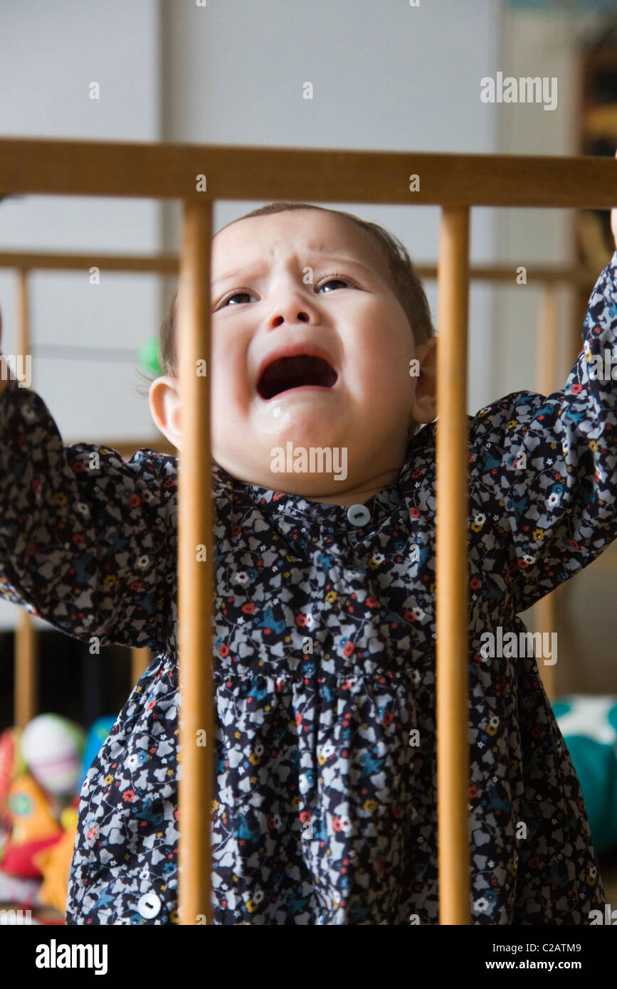 Baby girl crying in crib Stock Photo - Alamy