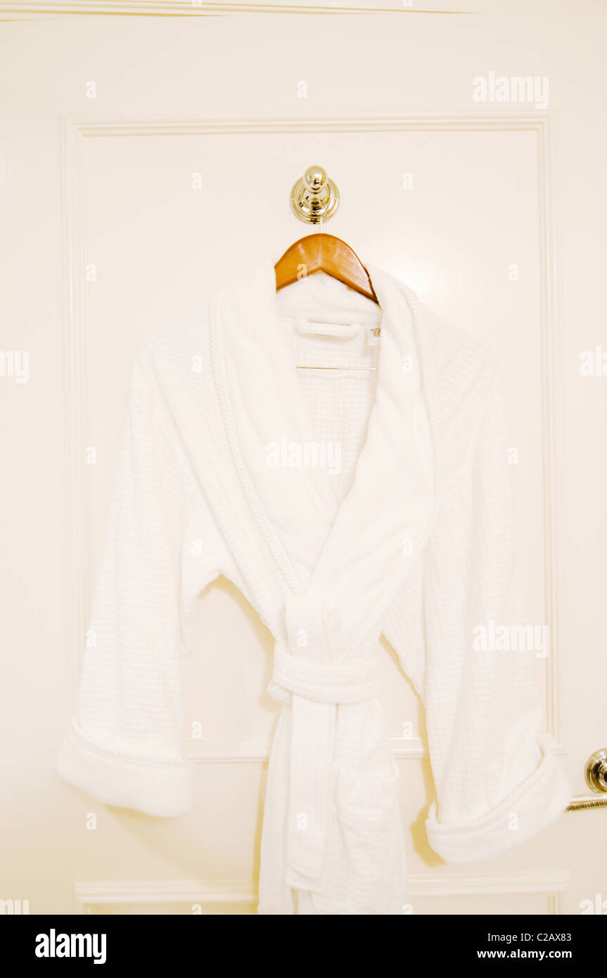 White bathrobe hanging on back of door Stock Photo - Alamy