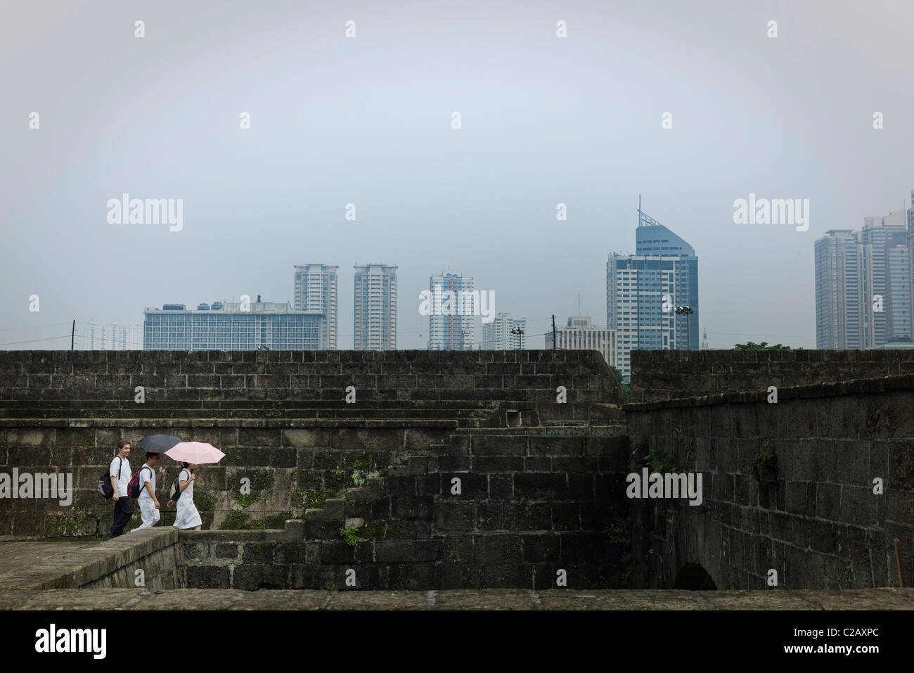 Philippines, Luzon, Manila, pedestrians walking up steps, city skyline ...