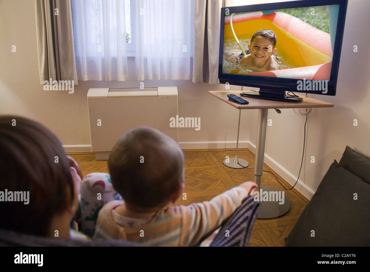 Siblings watching TV together Stock Photo - Alamy