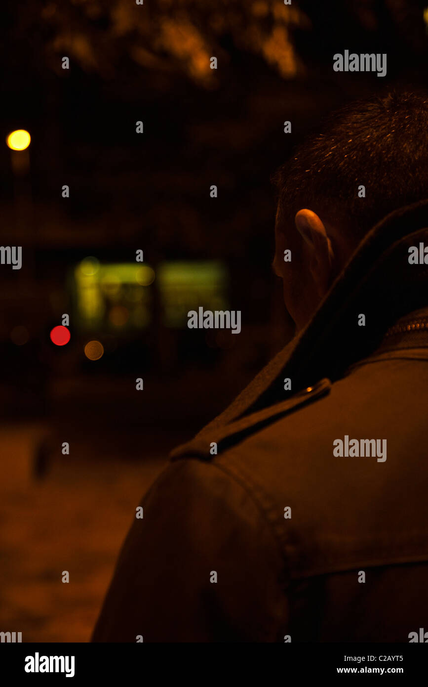 Man on the street at night, rear view Stock Photo - Alamy