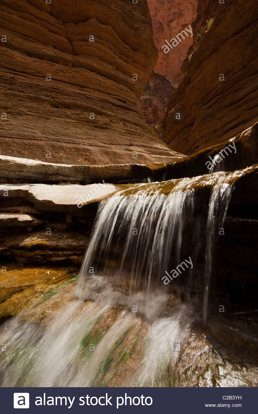 A clear waterfall flows over layers of desert rock Stock Photo - Alamy