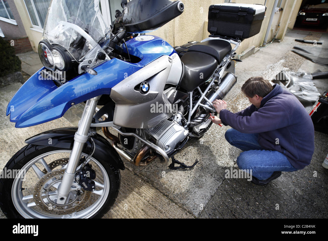 Man cleaning motorcycle in his driveway Stock Photo - Alamy