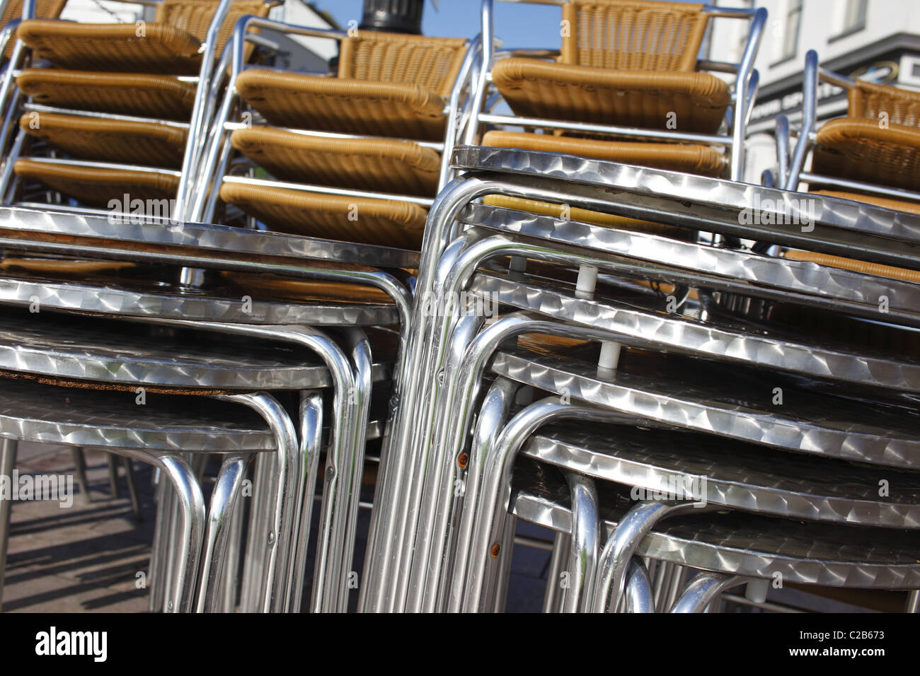 Stacked steel tables and chairs outside a restaurant Stock Photo - Alamy