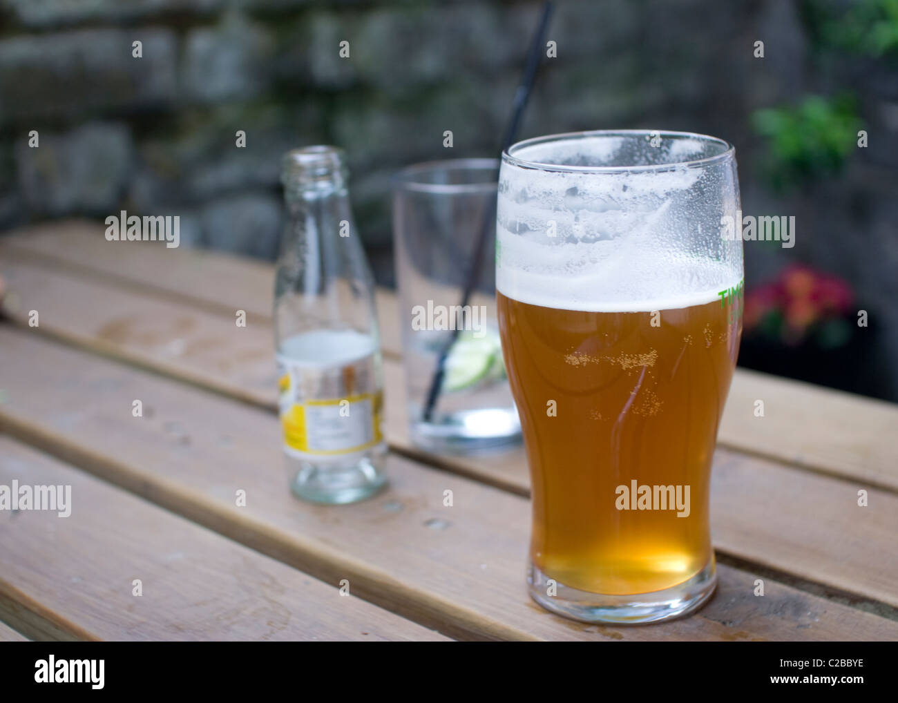 beer pint with empty gin and tonic on table in garden Stock Photo - Alamy