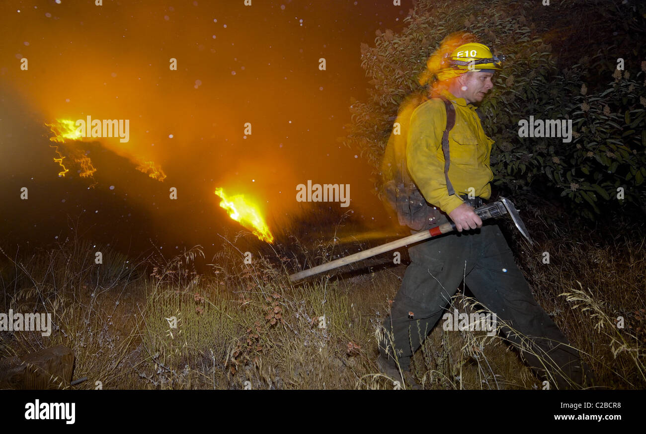 A fire fighter tries to control the fire at the burning woods in the ...