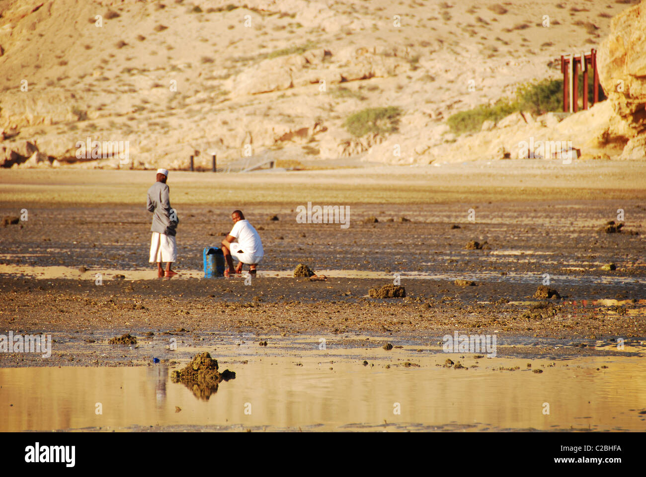 Oman, Sawadi, view of a man in traditional dress looking at a person in ...