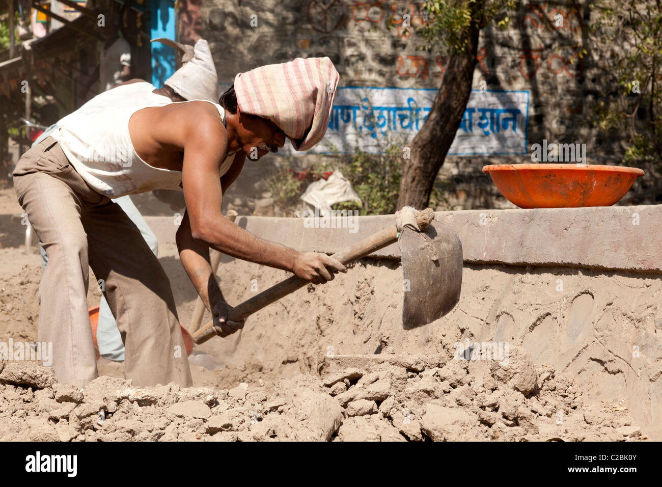 Indian male laborer repairing a road in the village of Valsang ...