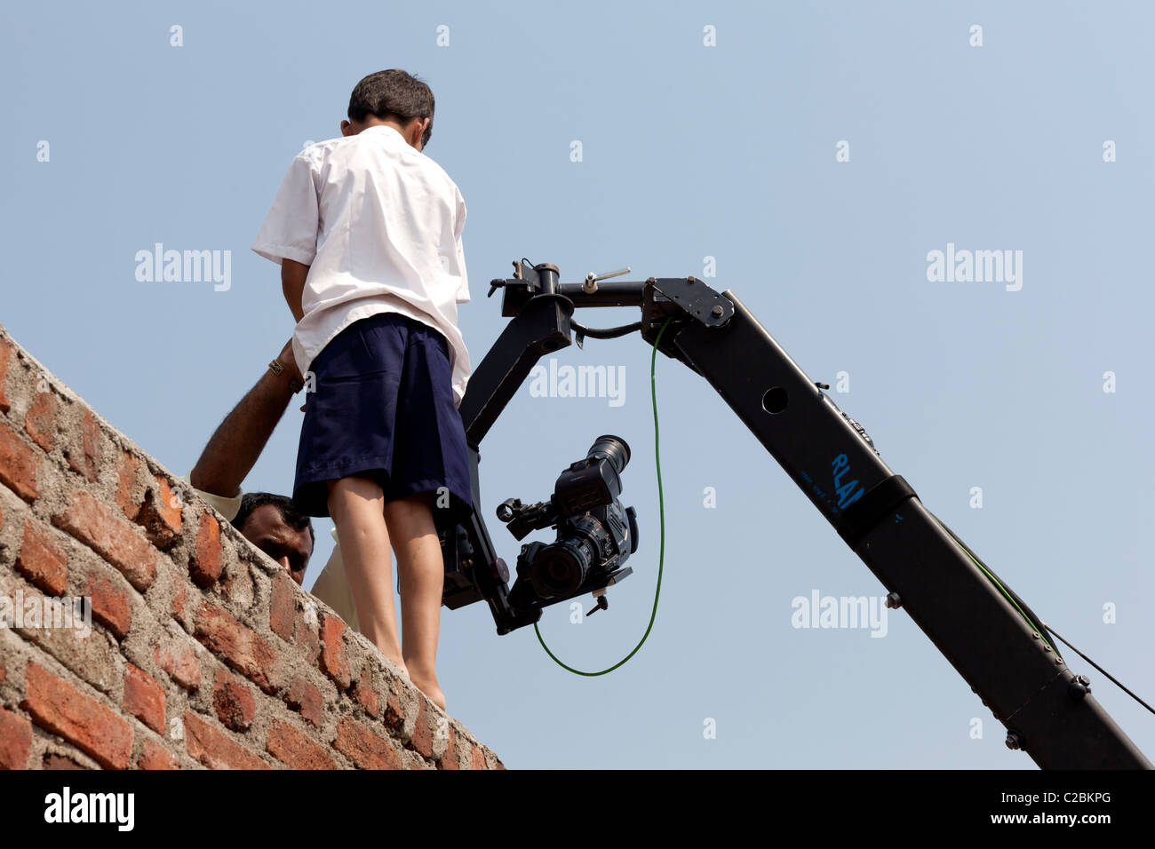 A boy actor prepares for an action shot using a Jimmy Jib camera crane ...
