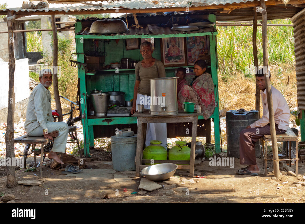 Men sitting at a stall selling chai in the Indian village of Valsang ...