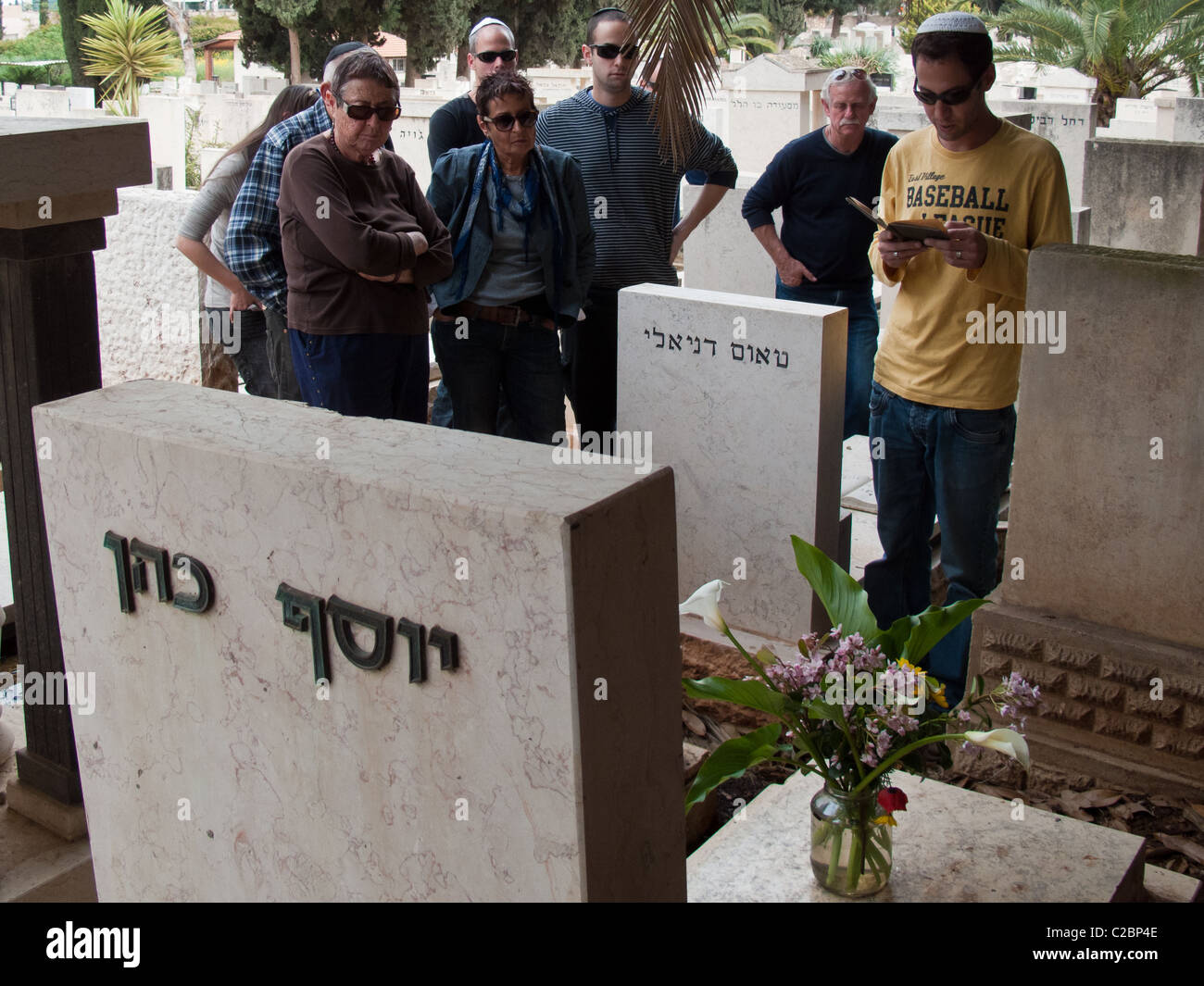 Secular Jewish family conducting a memorial service in cemetery Stock ...