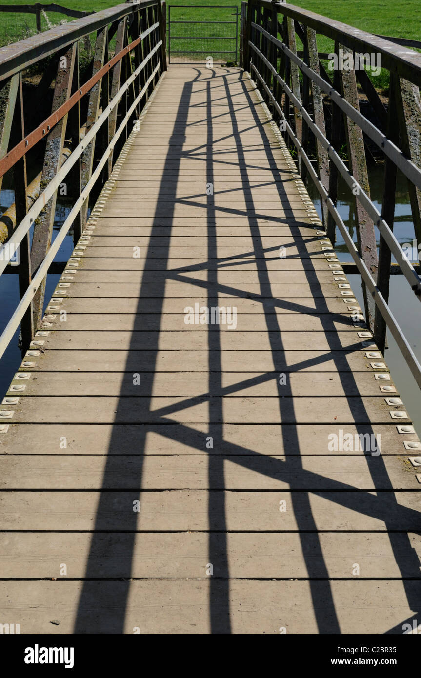 A metal footbridge with a wooden-plank footway leading to a gate Stock ...