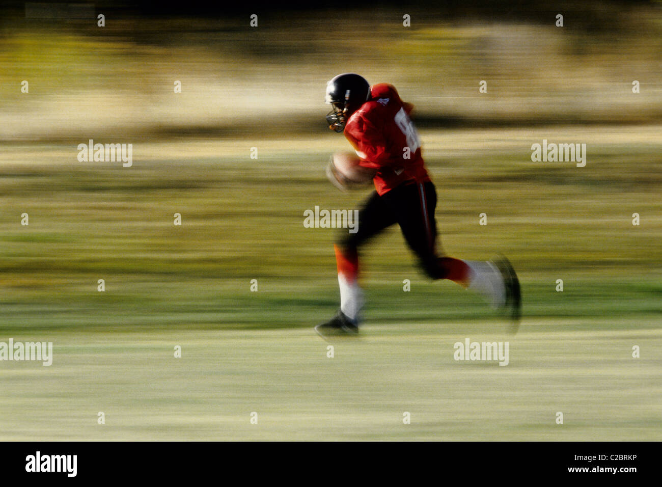 Football player running with the ball Stock Photo - Alamy