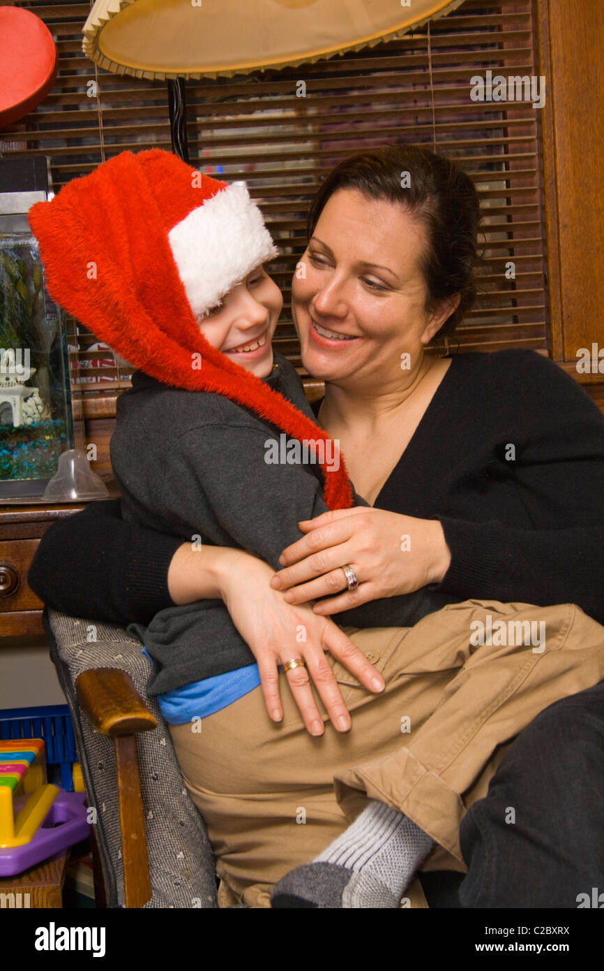 Mom and son in Santa hat affectionately celebrating a Christmas moment ...