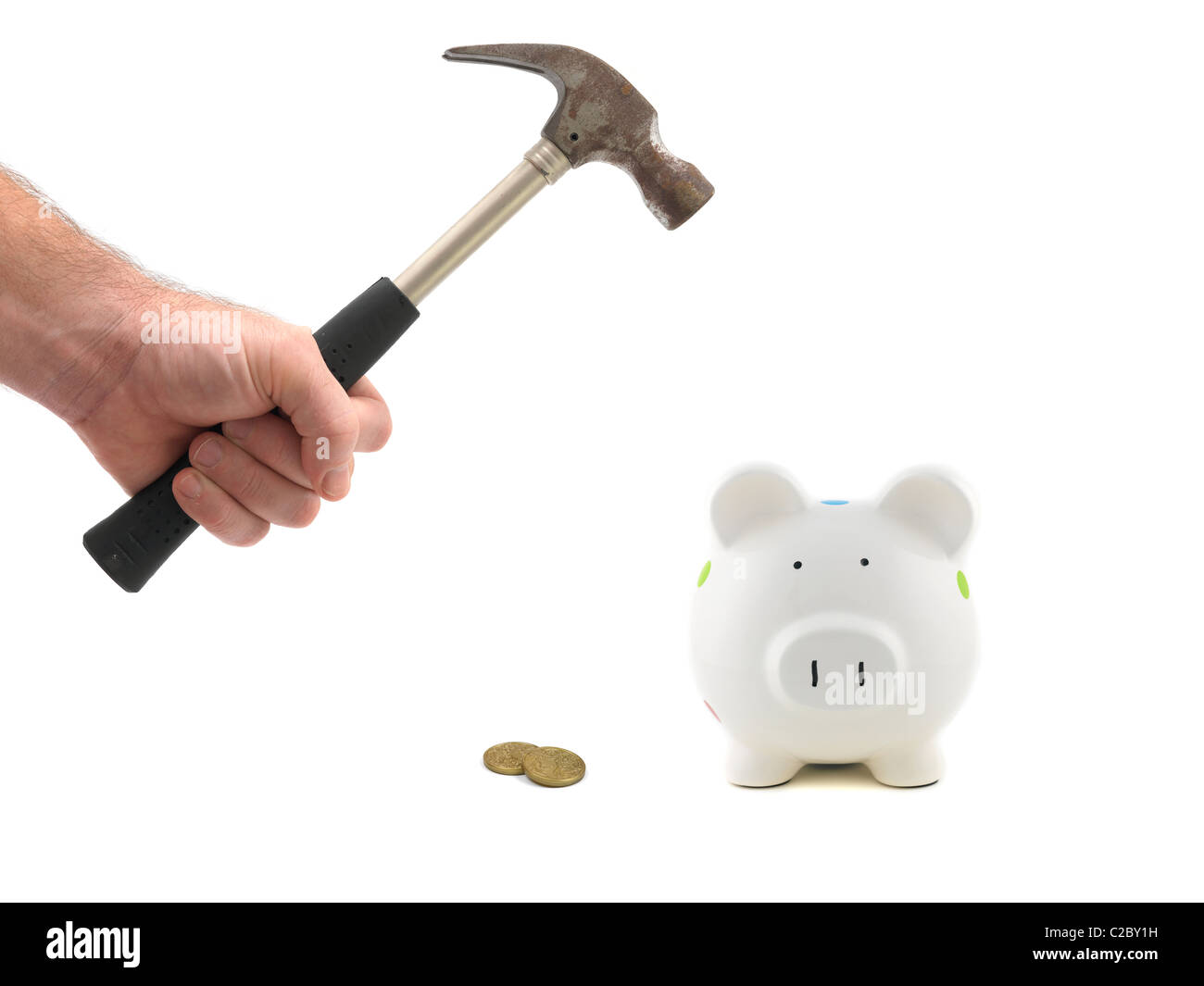 A metal hammer hammering a piggy bank isolated against a white ...