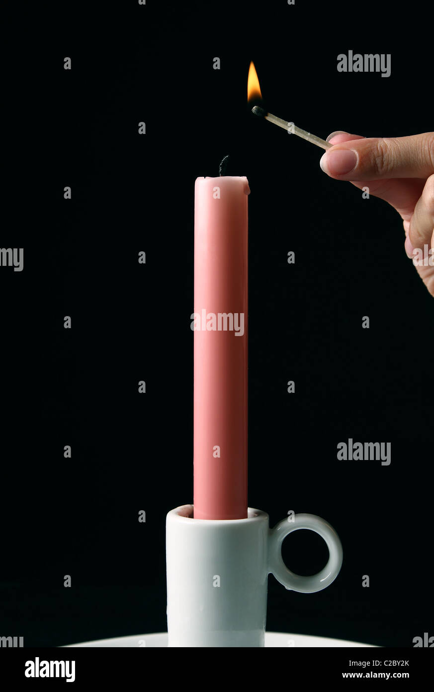 Hand lighting a candle Stock Photo - Alamy