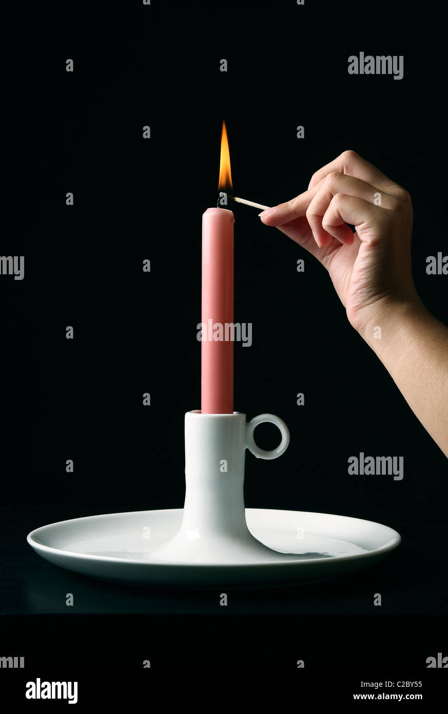 Hand lighting a candle Stock Photo - Alamy