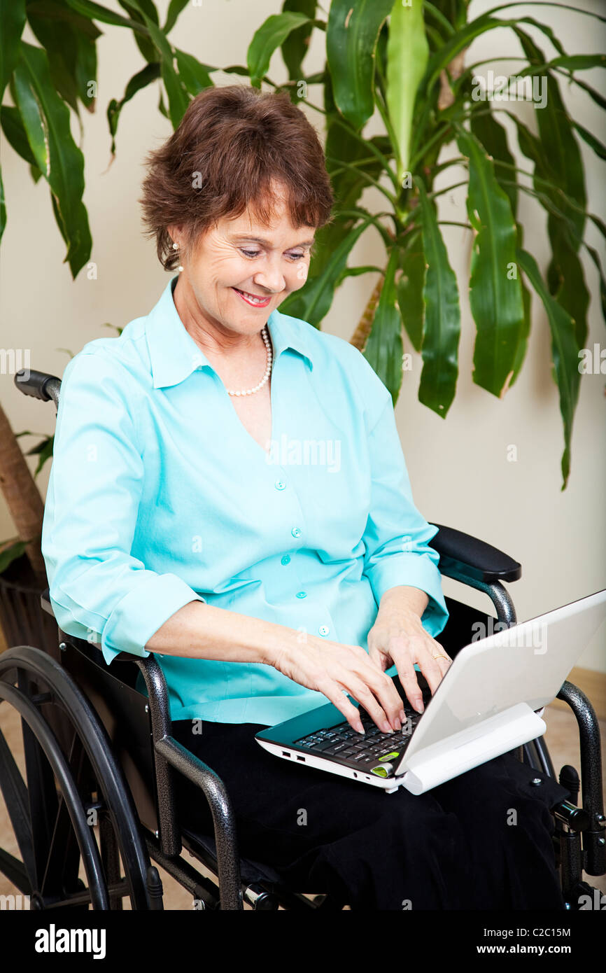 Disabled businesswoman using a tiny netbook computer Stock Photo - Alamy