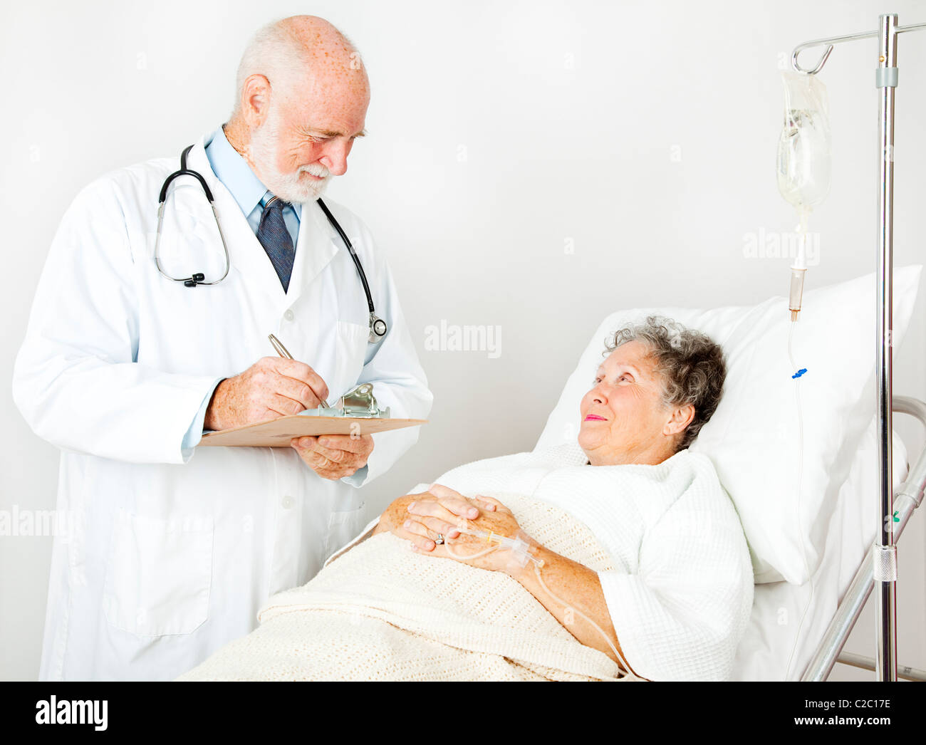 Doctor reviews his hospital patient's medical history, taking notes ...