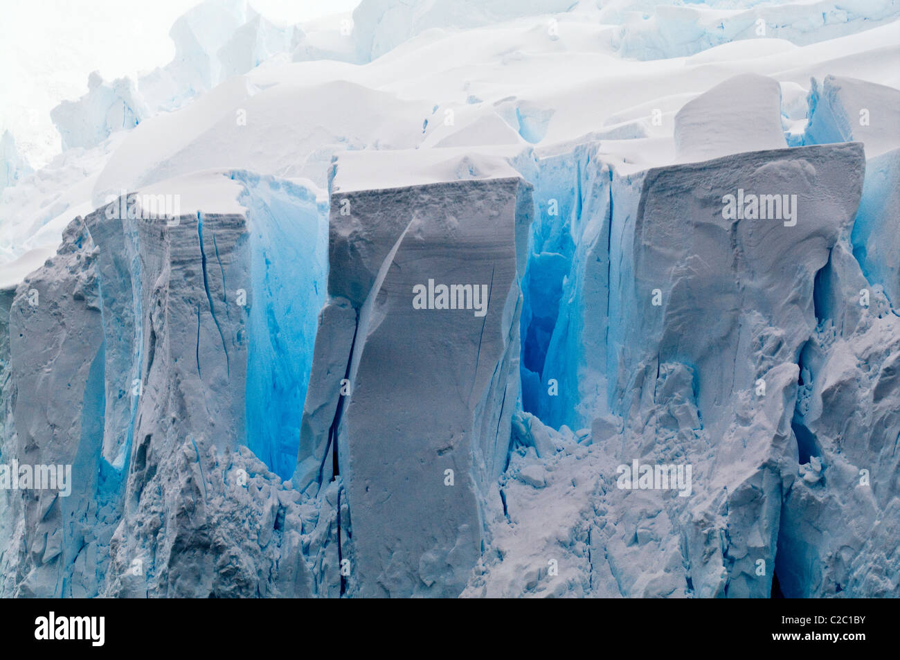 The fracture zone of massive glacial ice cliffs teeter over icy seas ...