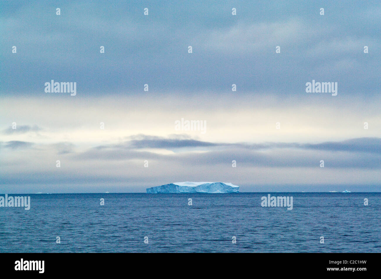 A lone iceberg floating in the open ocean after sunset Stock Photo - Alamy
