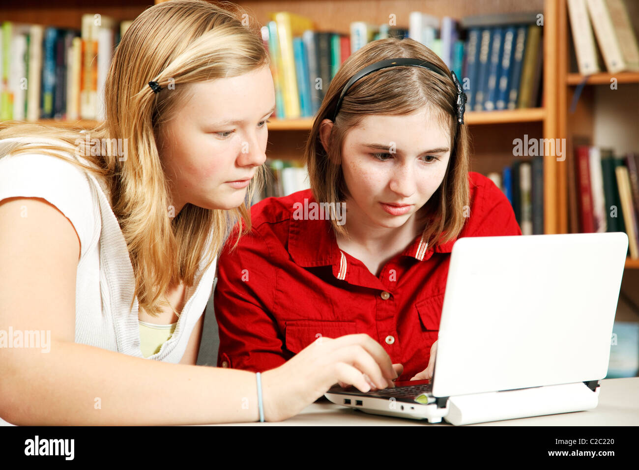 Two serious students using the computer to do homework in the school ...