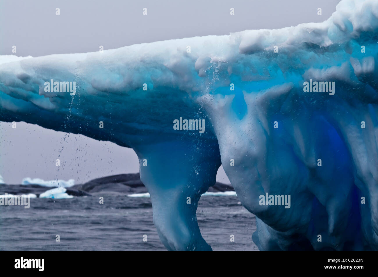 Rain and ice melt pour from the lip of a sculptured iceberg Stock Photo ...