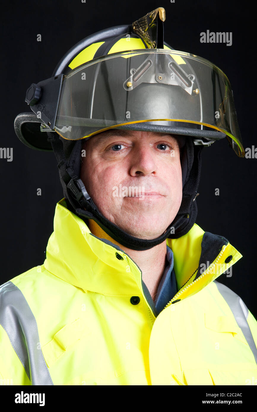 Head and shoulders portrait of a serious firefighter. Studio shot on ...