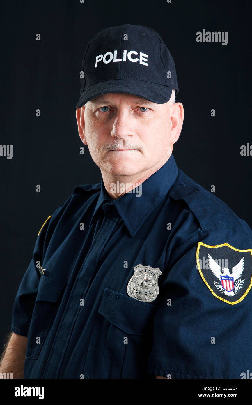 Portrait of a serious police officer, photographed over a black ...