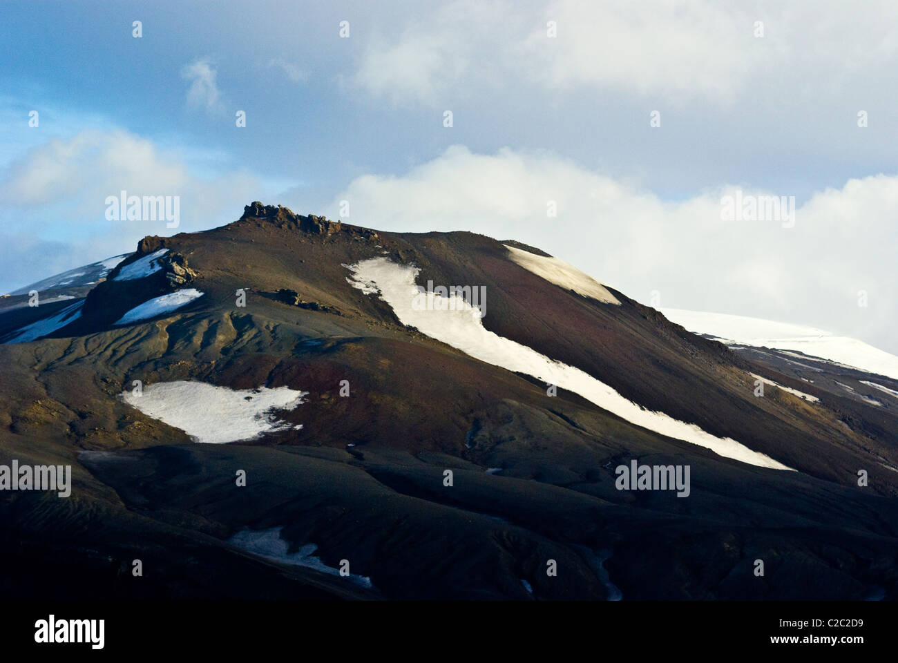Rugged snow and ice encrusted mountain surrounding a volcanic caldera ...