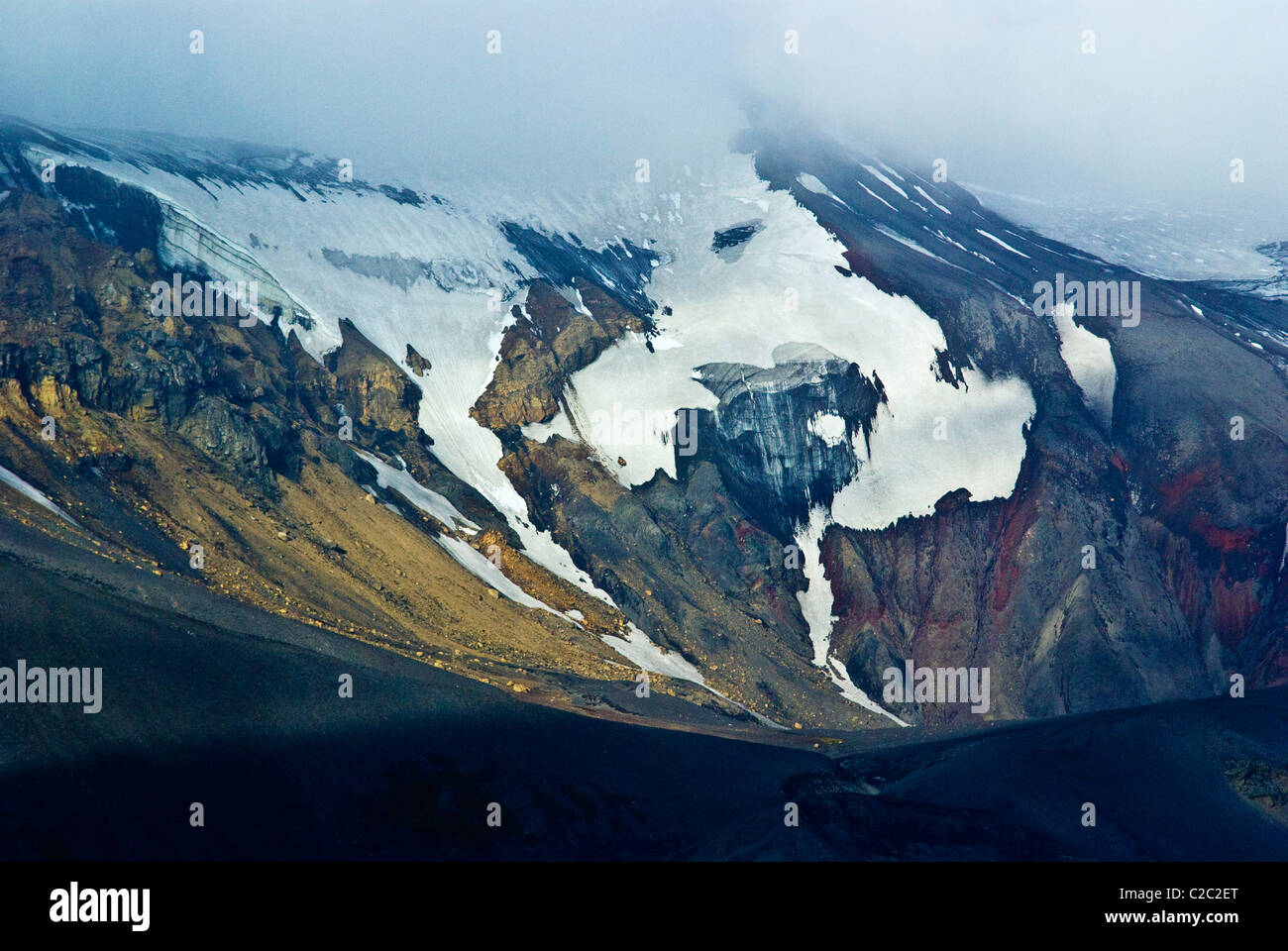 Rugged snow and ice encrusted mountain surrounding a volcanic caldera ...