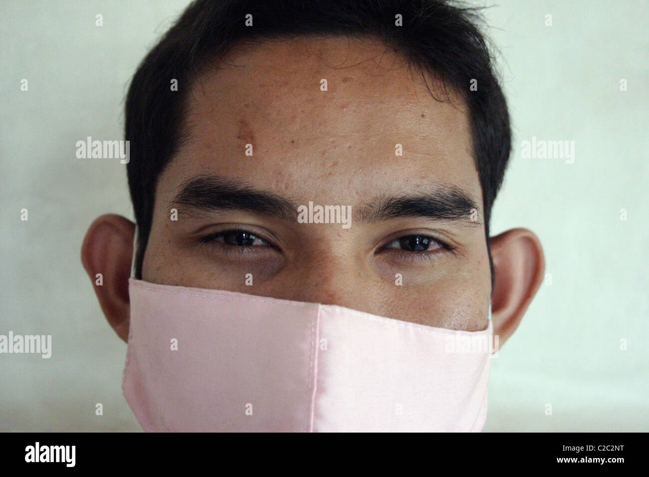 A young Asian man is wearing a face mask to protect himself from toxic ...