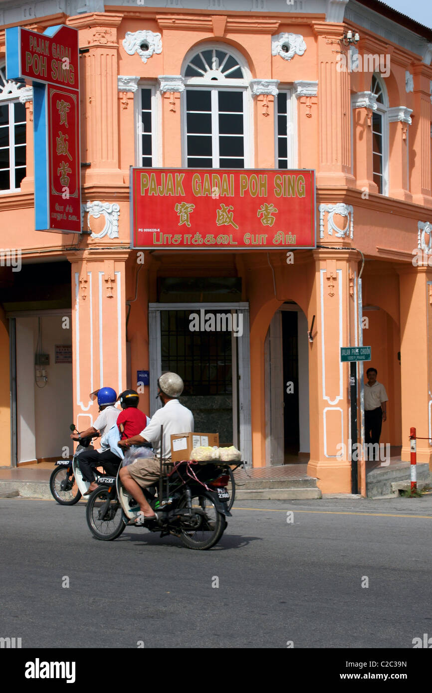 Men riding motorcycles are passing a colorfully painted building on a ...