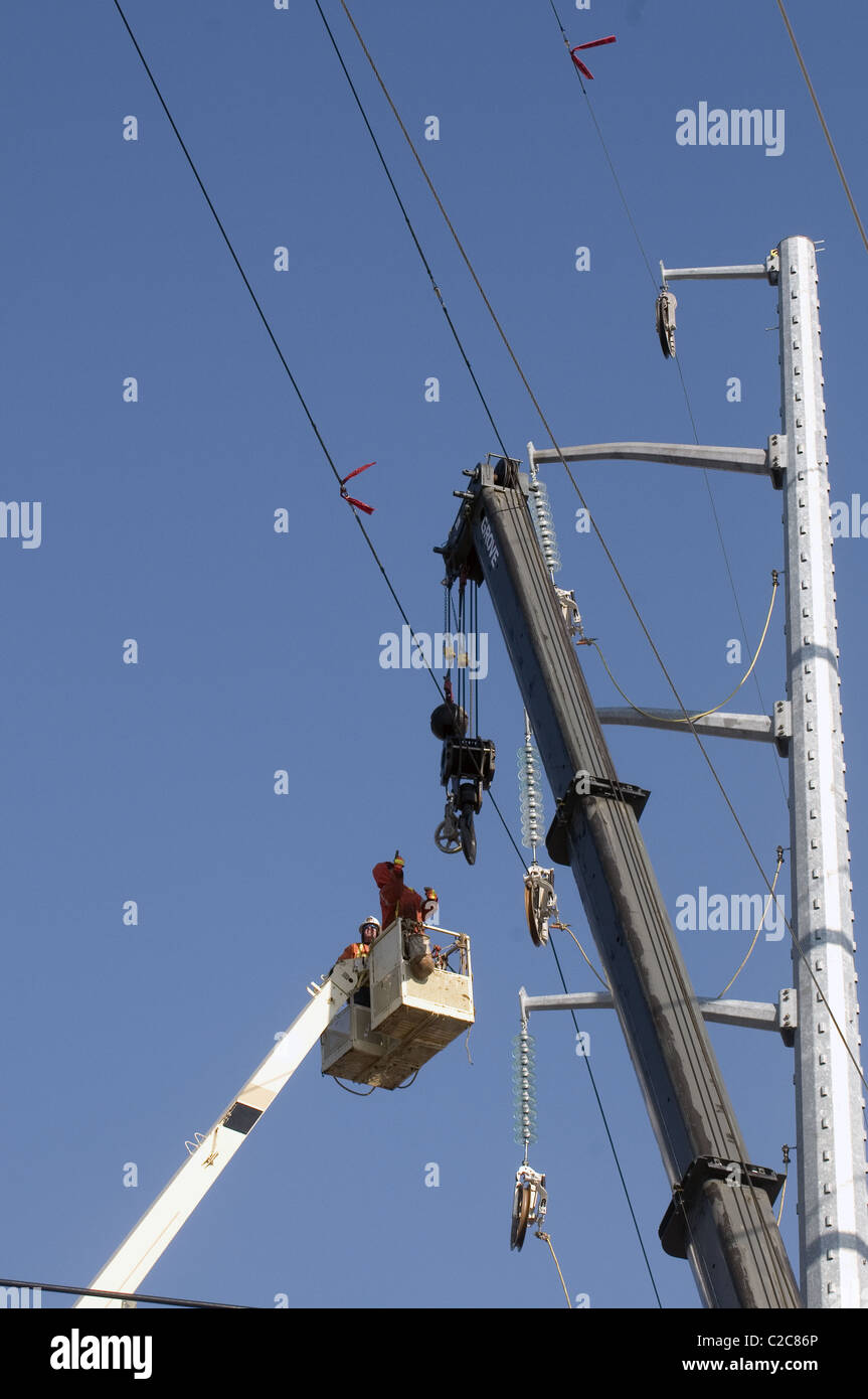 Man working on high power lines and tower Stock Photo - Alamy