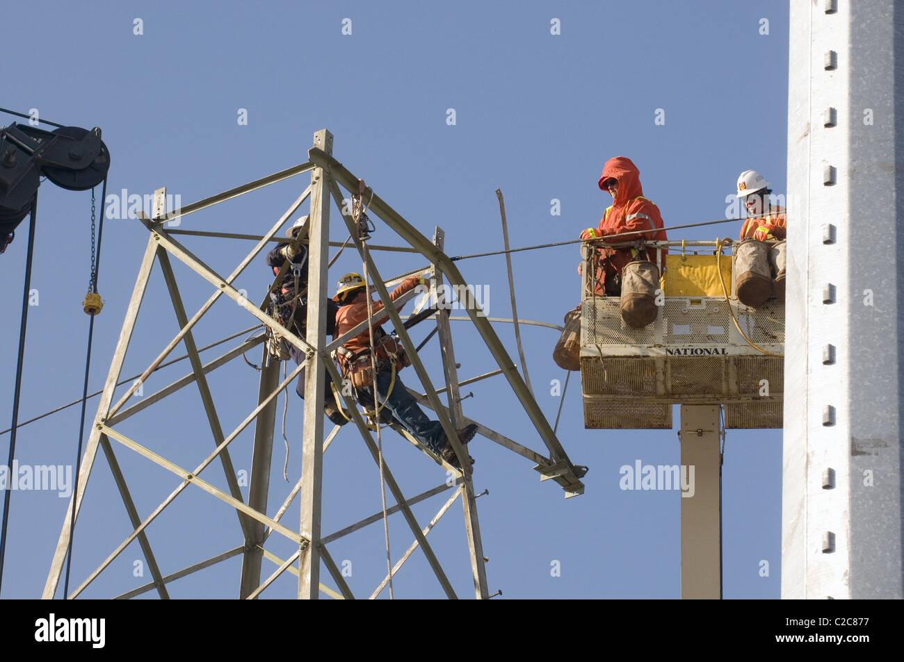 Men working on high power lines and tower Stock Photo - Alamy